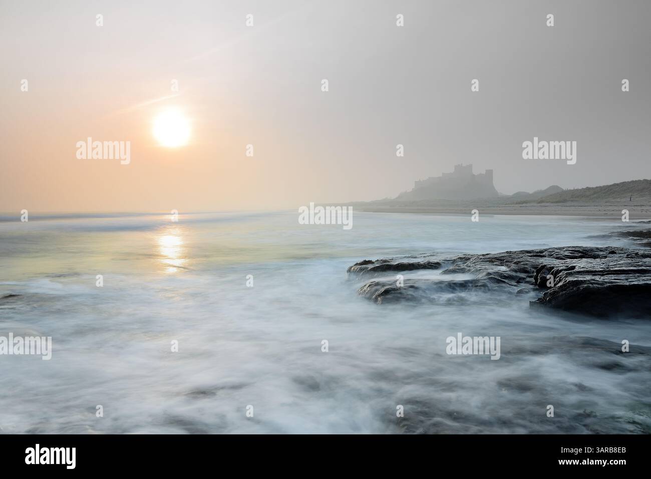 Long exposure scene of the sun breaking through thick fog surrounding ...