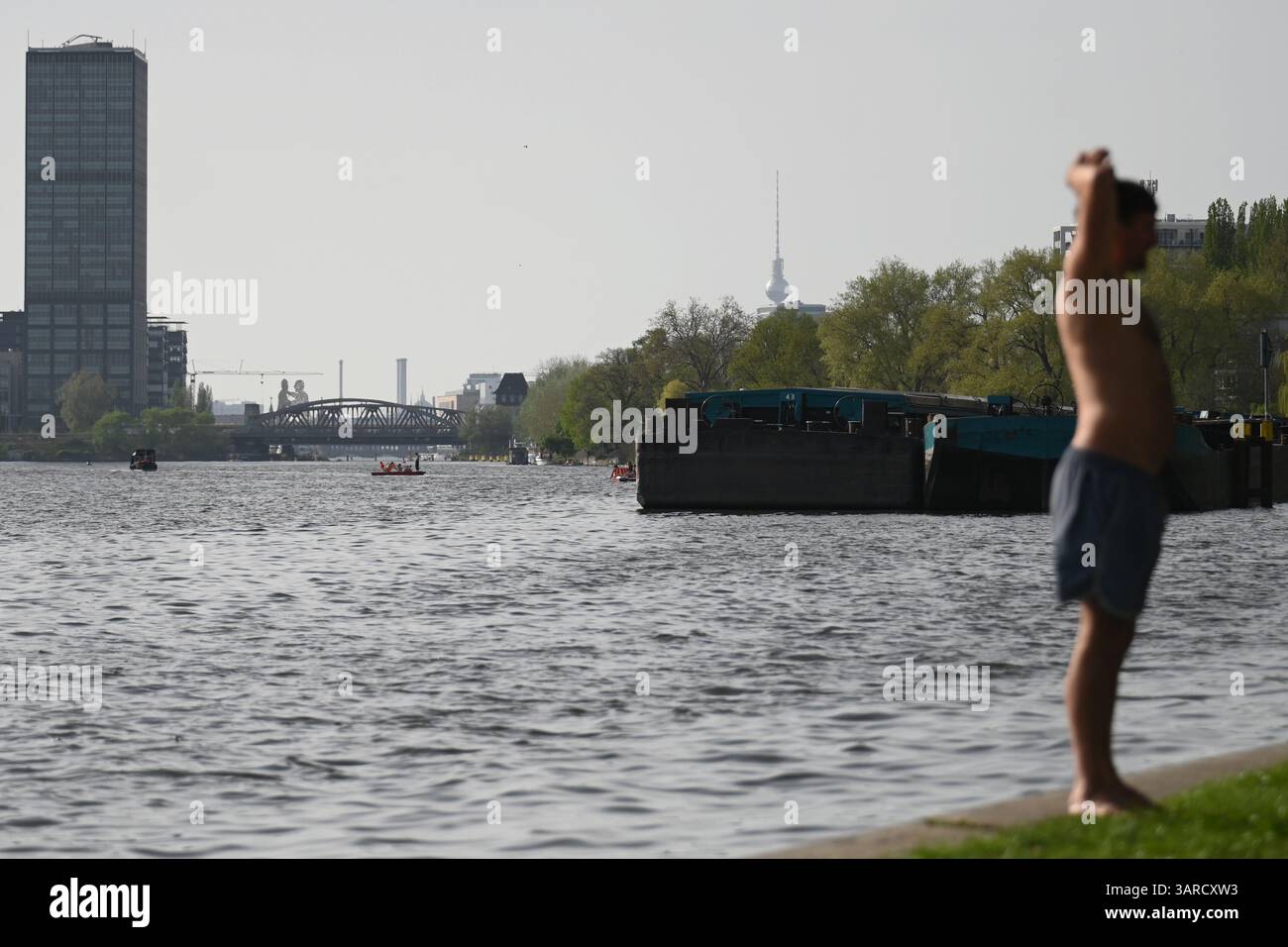 17 April 2025, Berlin: Tobi stands in his swimming trunks on the Spree ...
