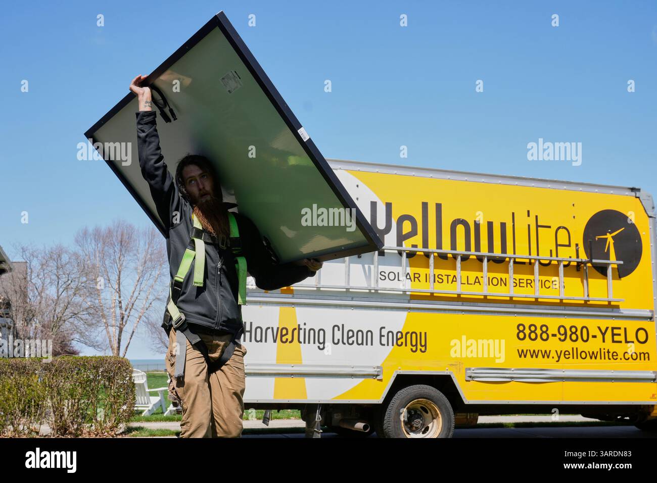 Theodore Tanczuk, of solar installer YellowLite, carries a solar panel ...