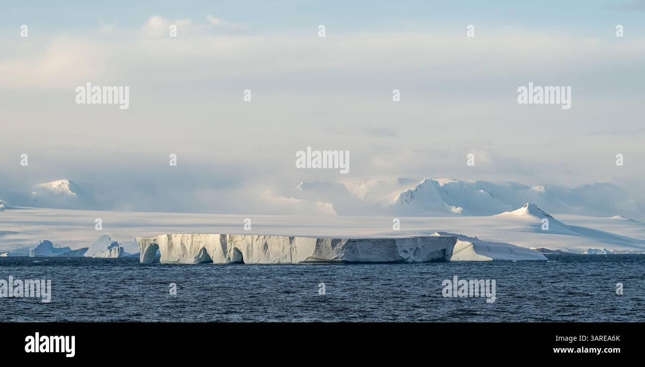 A large tabular iceberg in front of snow covered mountains near Cape ...