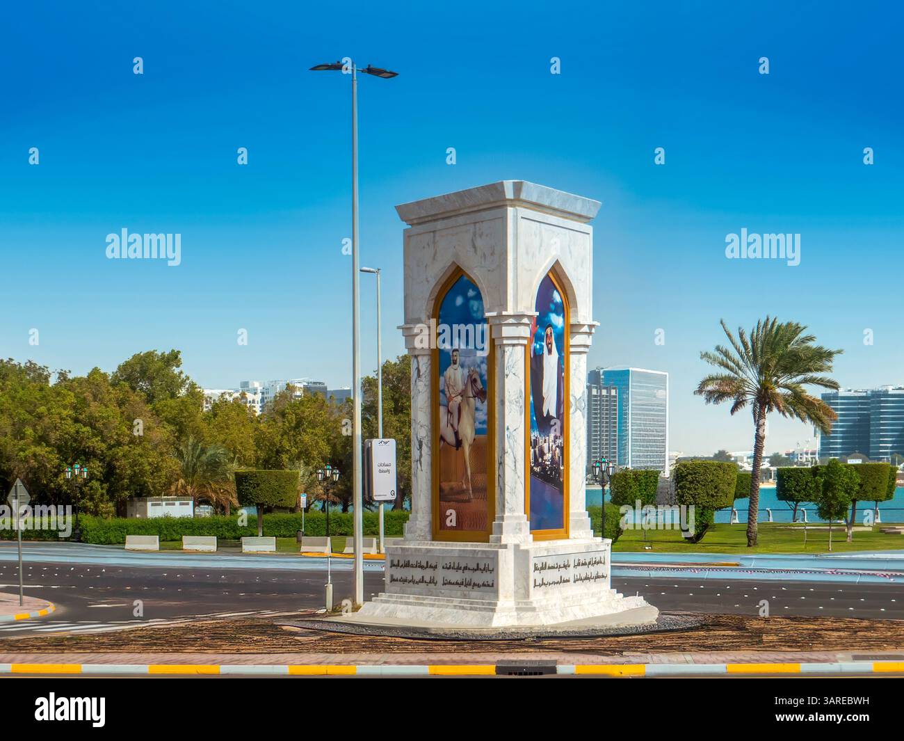 Abu Dhabi road junction with portrait on monument with colourful flower ...