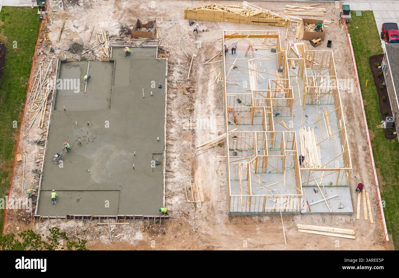Workers smooth and polish concrete slab floor while other construct ...