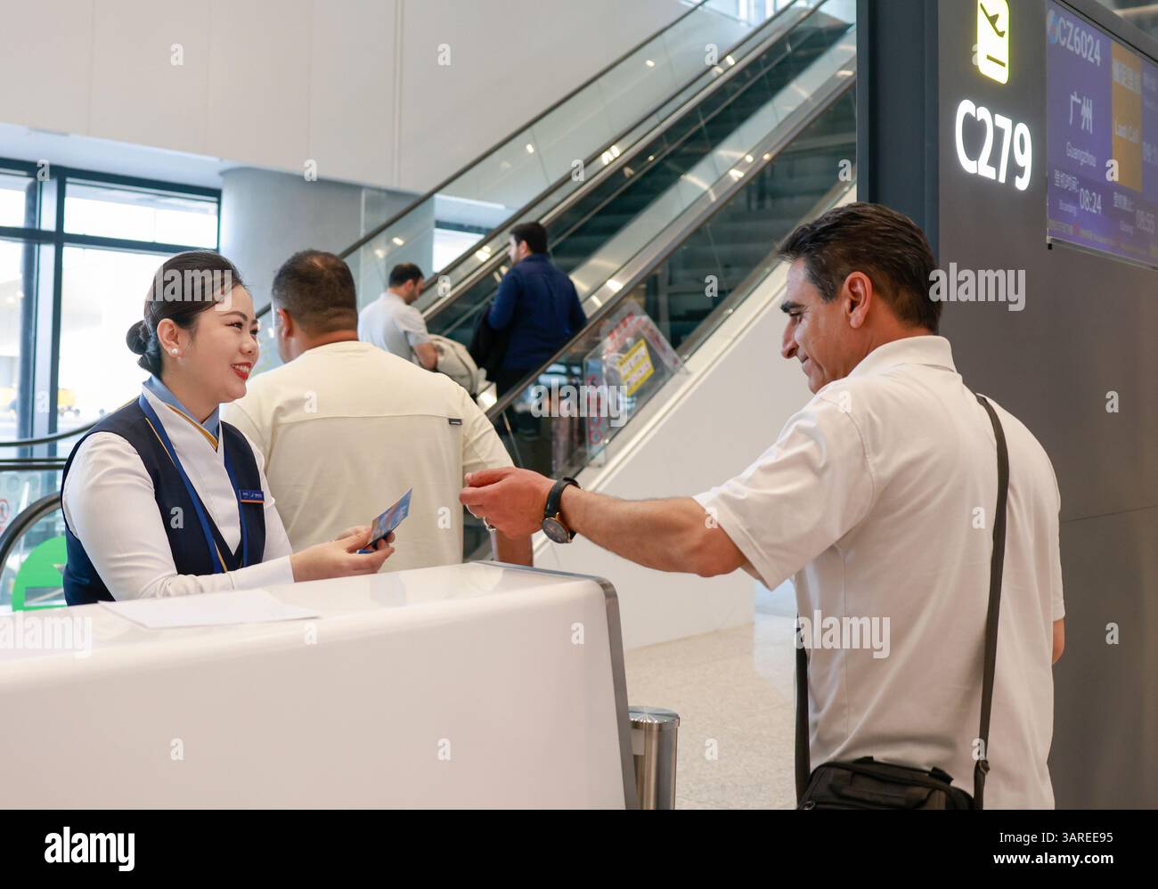 (250417) -- URUMQI, April 17, 2025 (Xinhua) -- A passenger checks in at ...