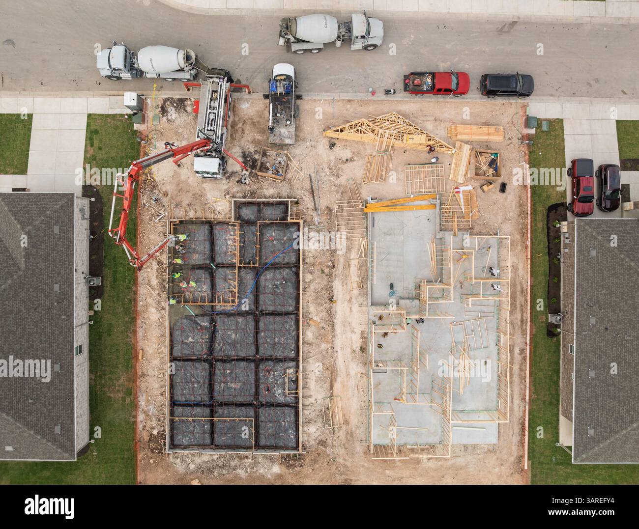 Concrete pump and truck pumping concrete into home foundations while ...