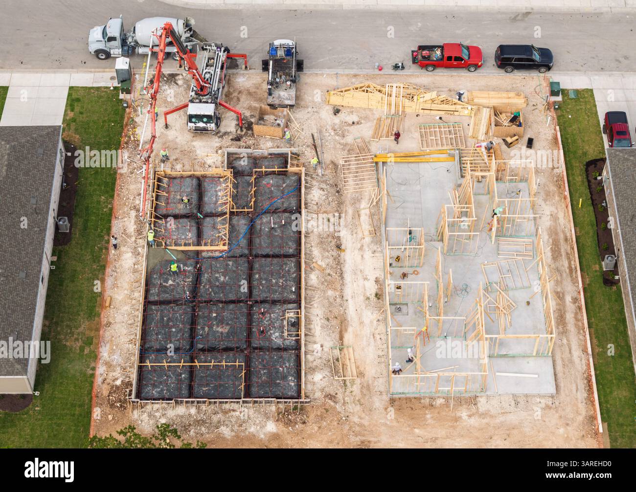Concrete pump and truck pumping concrete into home foundations while ...