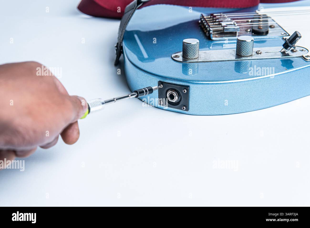 Close-up of a hand using a screwdriver to repair or install the input ...
