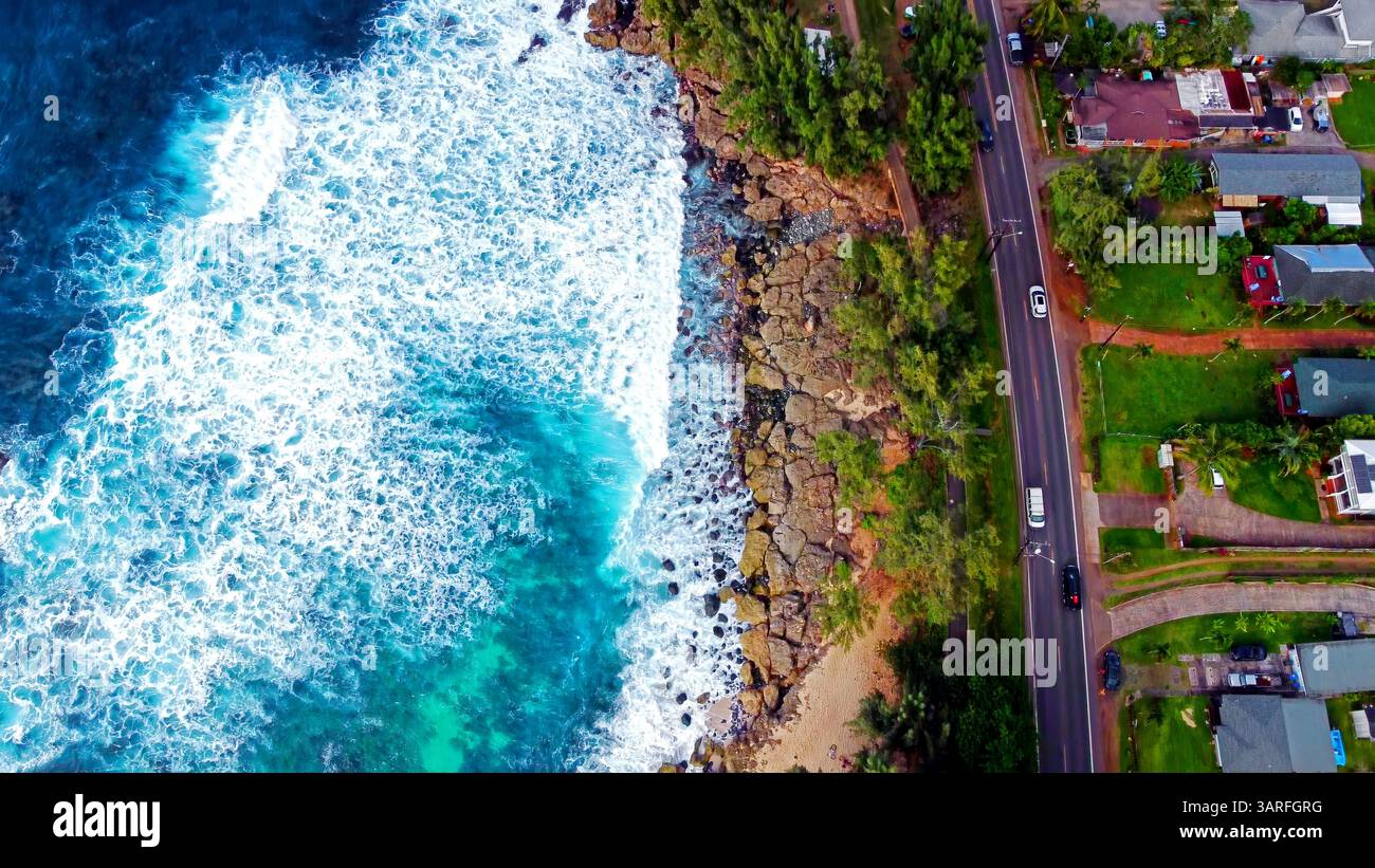 Aerial view of coastal road and ocean waves. Top-down drone shot showing a vibrant coastline ...