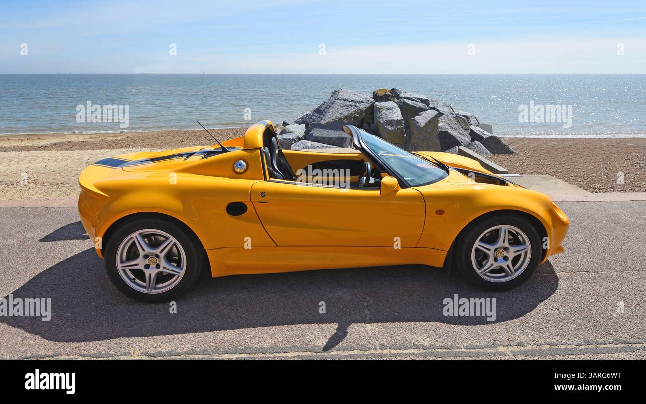 Classic Yellow Lotus Elise S1 sports car on seafront beach and sea in ...