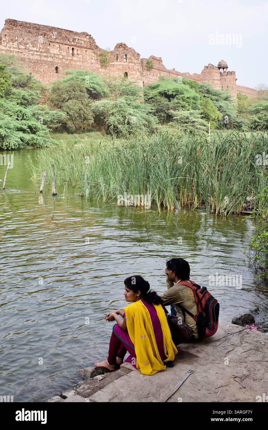 A couple relaxes beside the reed-lined lake at Purana Qila, New Delhi ...