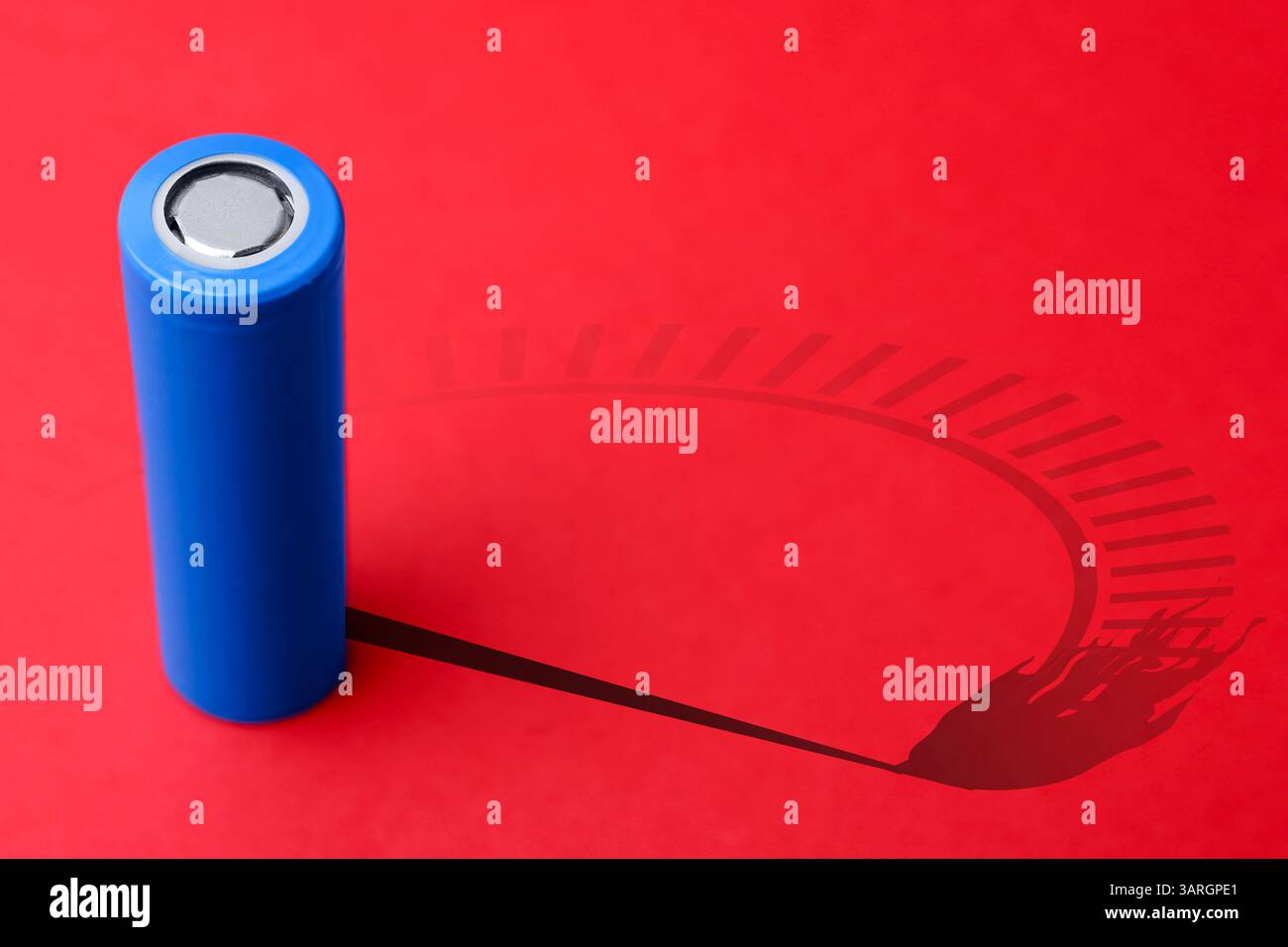 Alkaline battery with shadow in shape of speedometer on red background ...