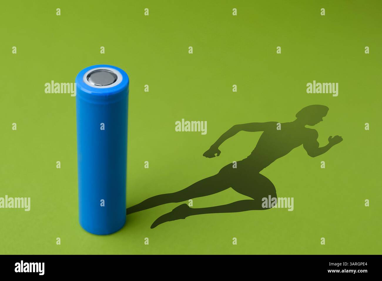 Alkaline battery with shadow in shape of running man on green ...