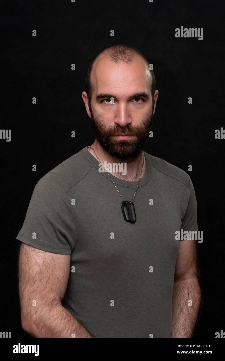 Portrait of a balding man 30-36 years old in a military T-shirt with ...