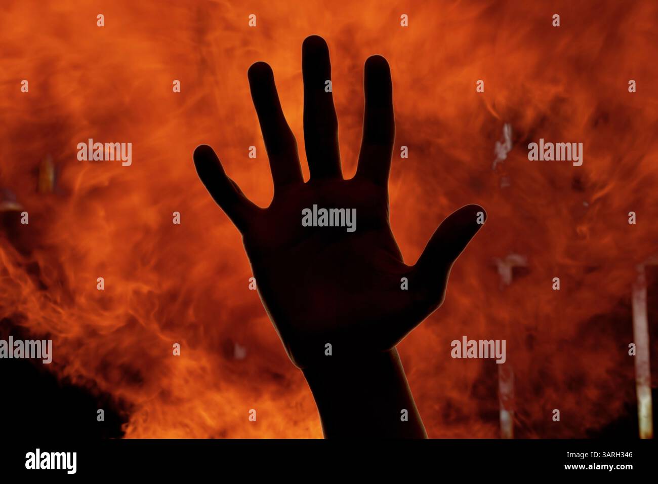 Hand in the background of fire and fire, burning house. Concept: death ...