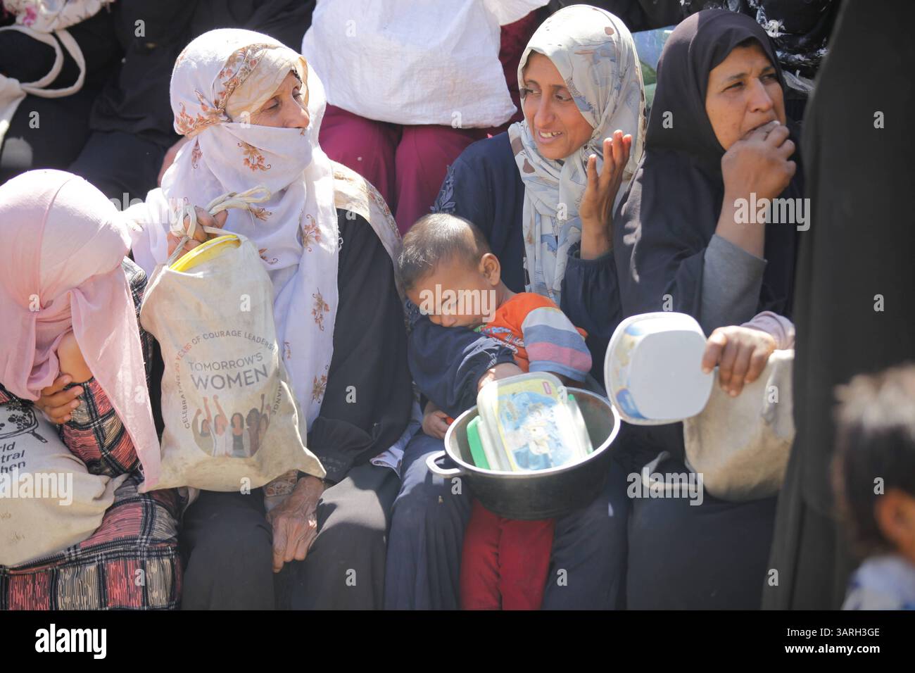 Palestinians gather in large numbers to receive the meals distributed ...