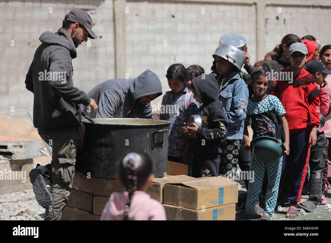 Palestinians gather in large numbers to receive the meals distributed ...