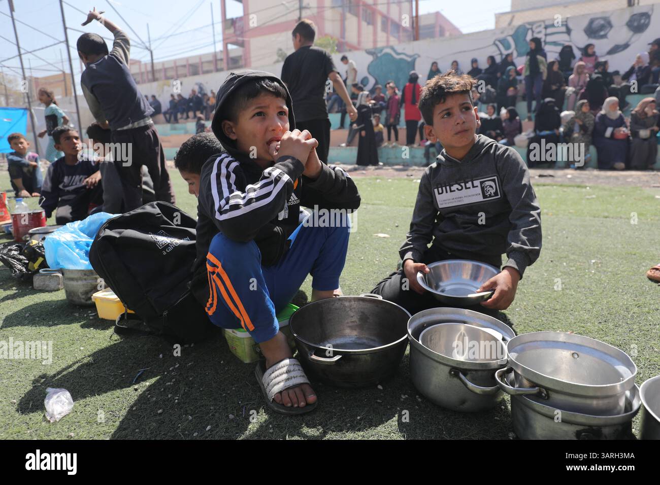 Palestinians gather in large numbers to receive the meals distributed ...