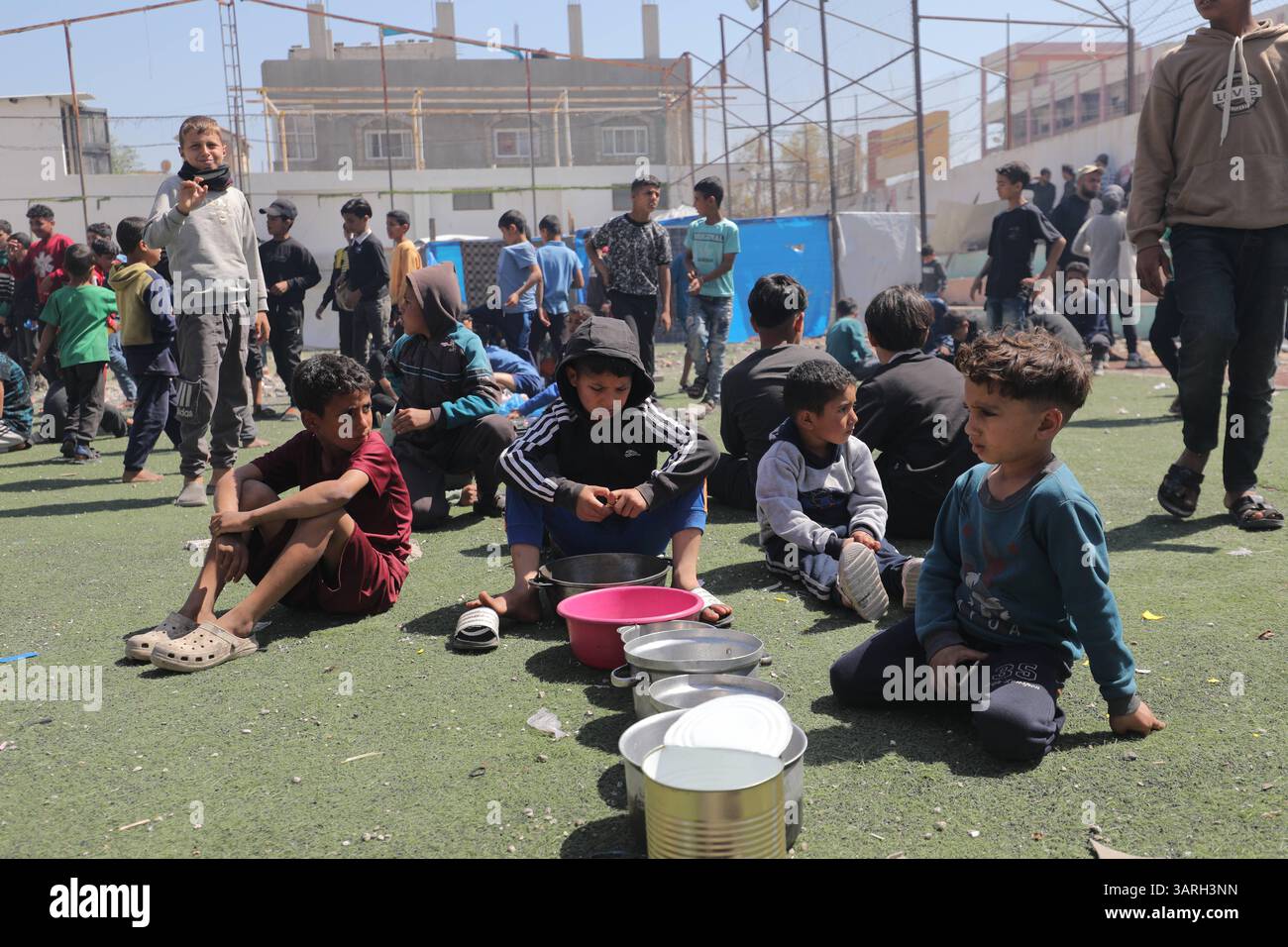 Palestinians gather in large numbers to receive the meals distributed ...