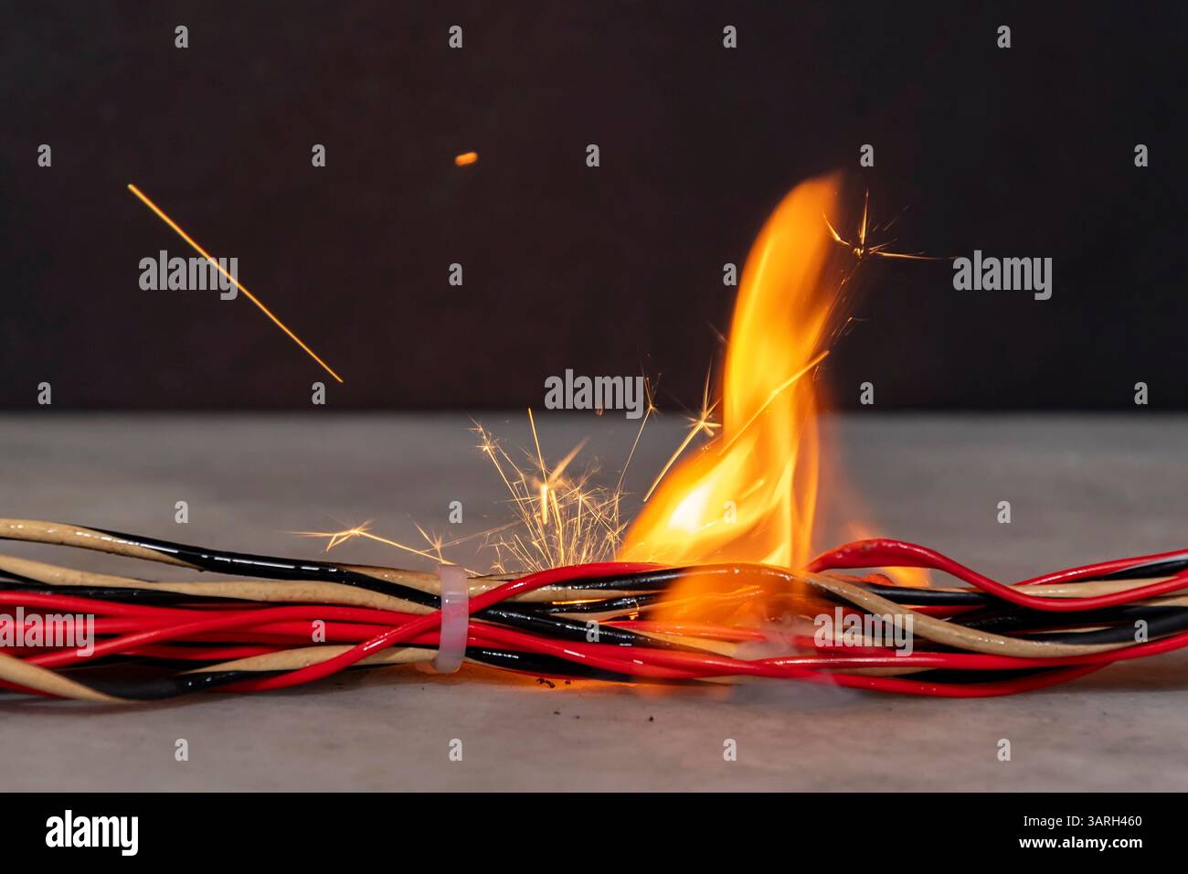 Ignition and fire in electrical wires on a dark background. A short ...