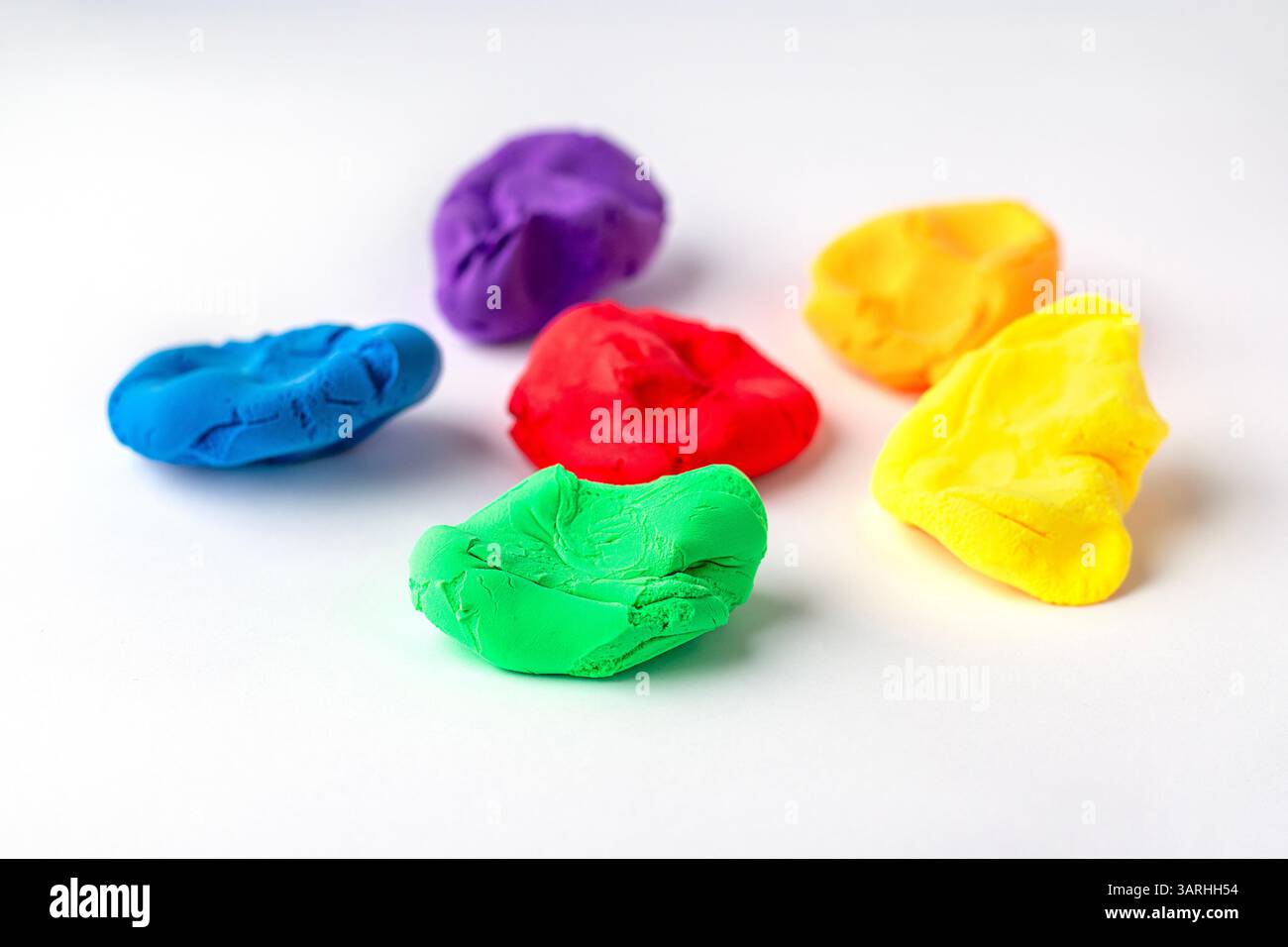 Brightly colored modeling clay lumps in blue, green, red, yellow, and ...