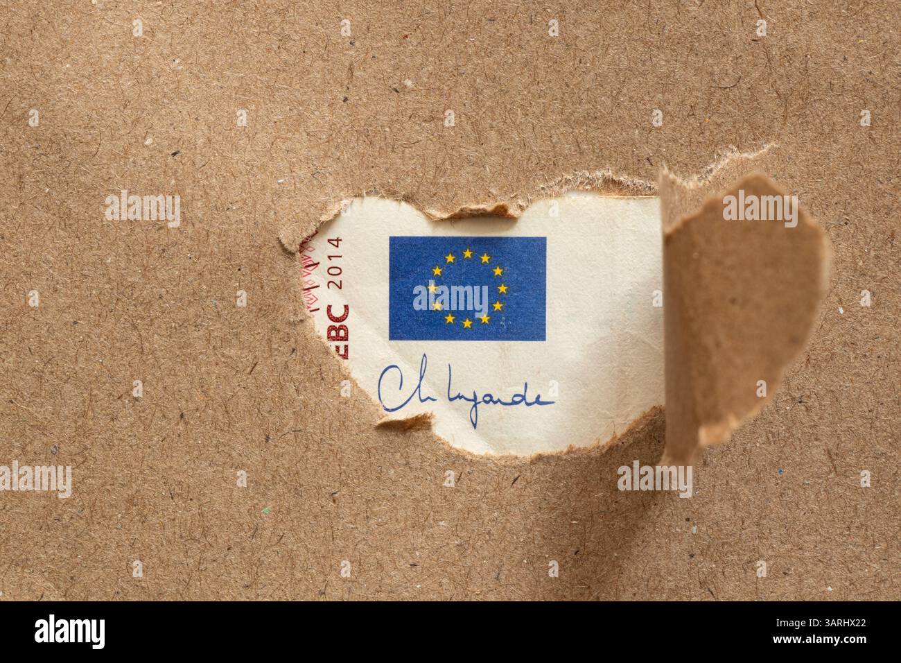 A hole in the paper through which the EU flag is visible on a ten euro ...