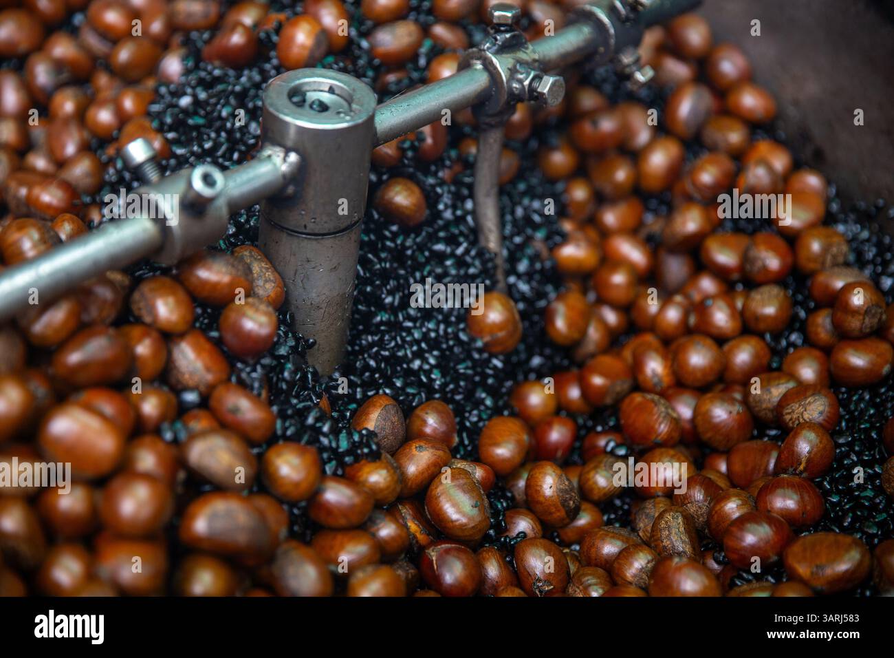 Roasting Chestnuts churning with coal Stock Photo - Alamy
