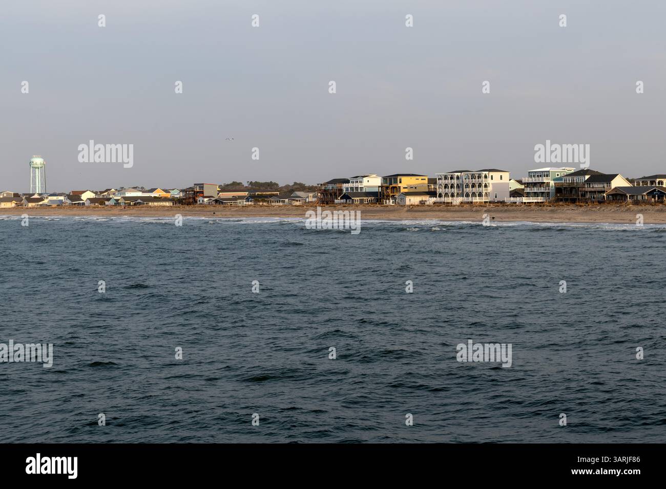 Distant view of oceanfront homes line the shore at Oak Island, North ...