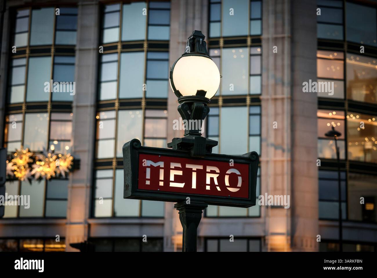 The sign at a metro station lights up in the early evening in Paris ...