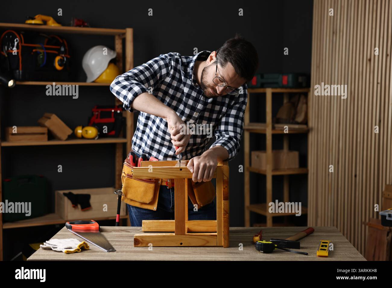 Carpenter repairing stool at table in workshop Stock Photo - Alamy