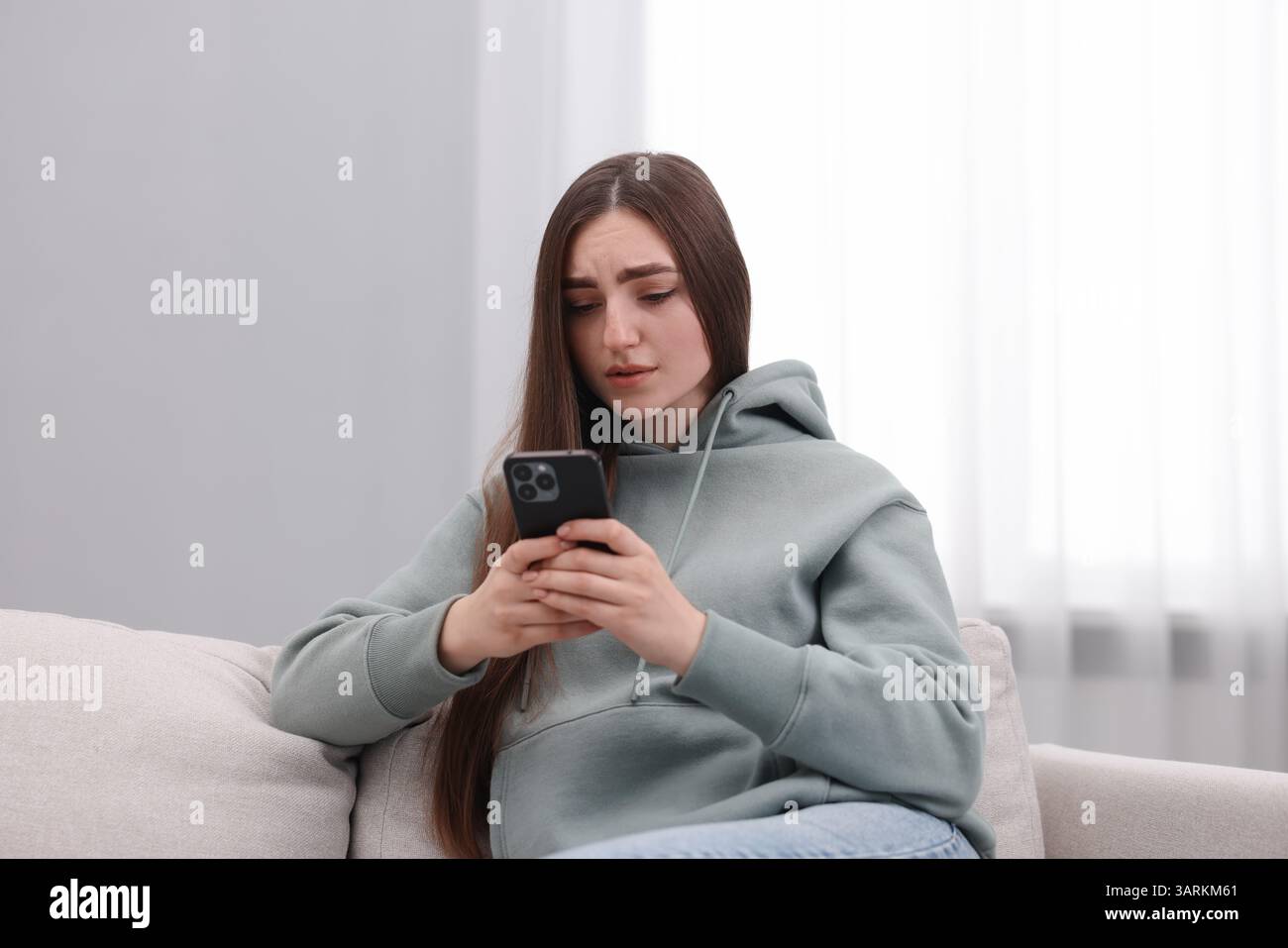 Depressed woman calling hotline for mental health help on sofa at home ...