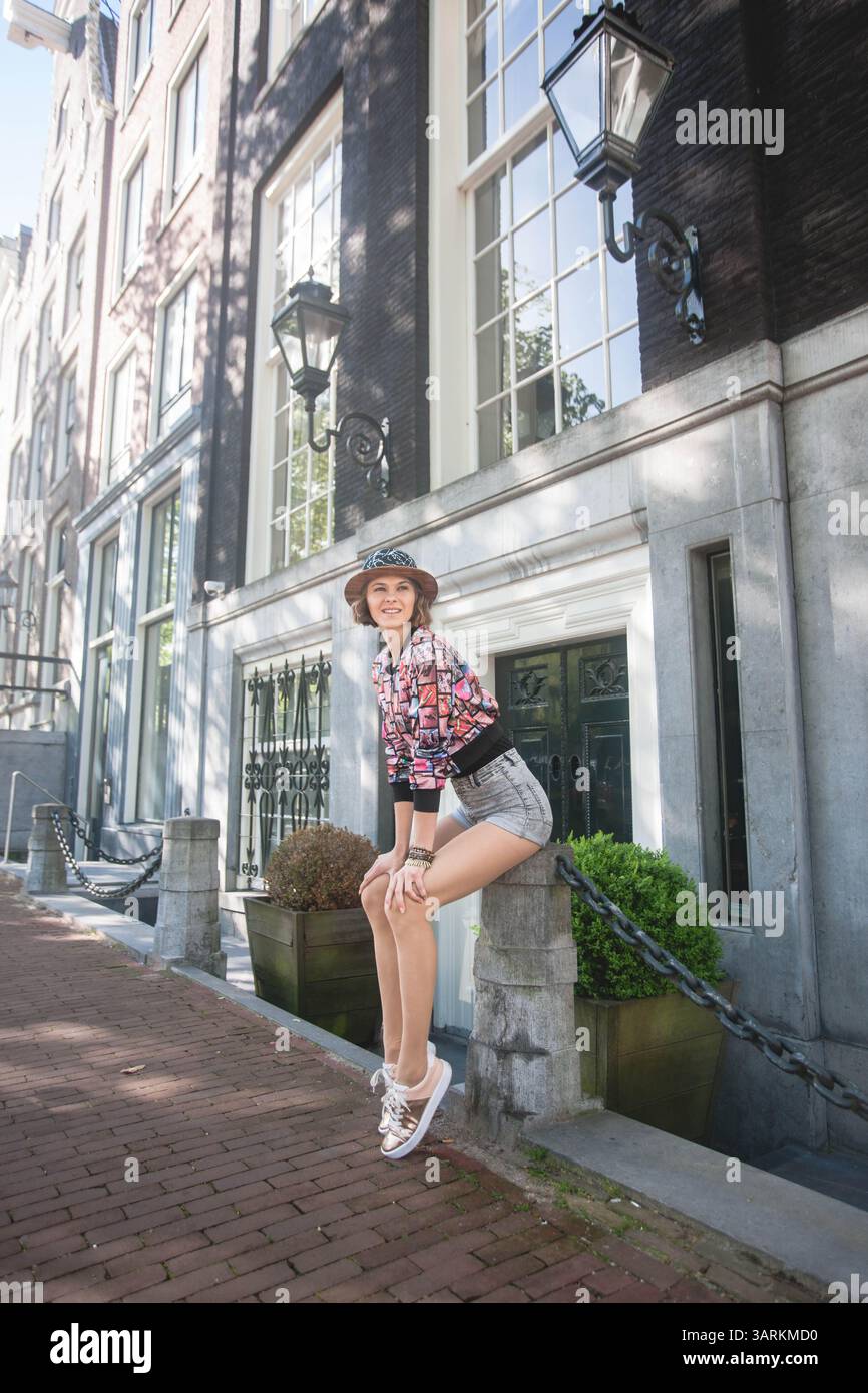 Beautiful happy young woman posing on the stylish streets of Amsterdam ...