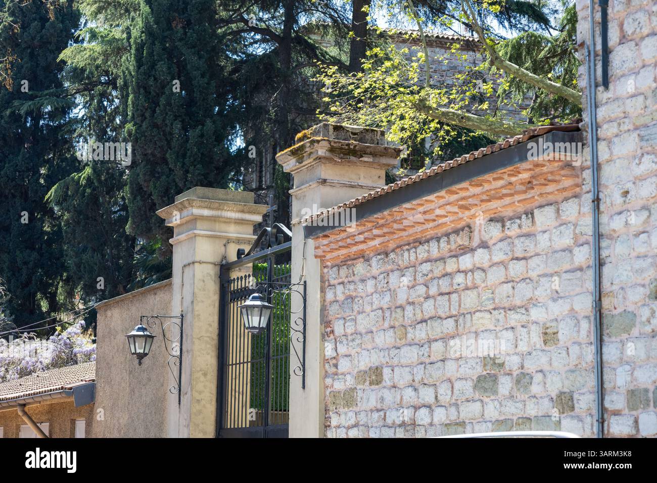 Historic Stone Wall and Iron Gate with Lanterns in a Lush Garden Stock ...