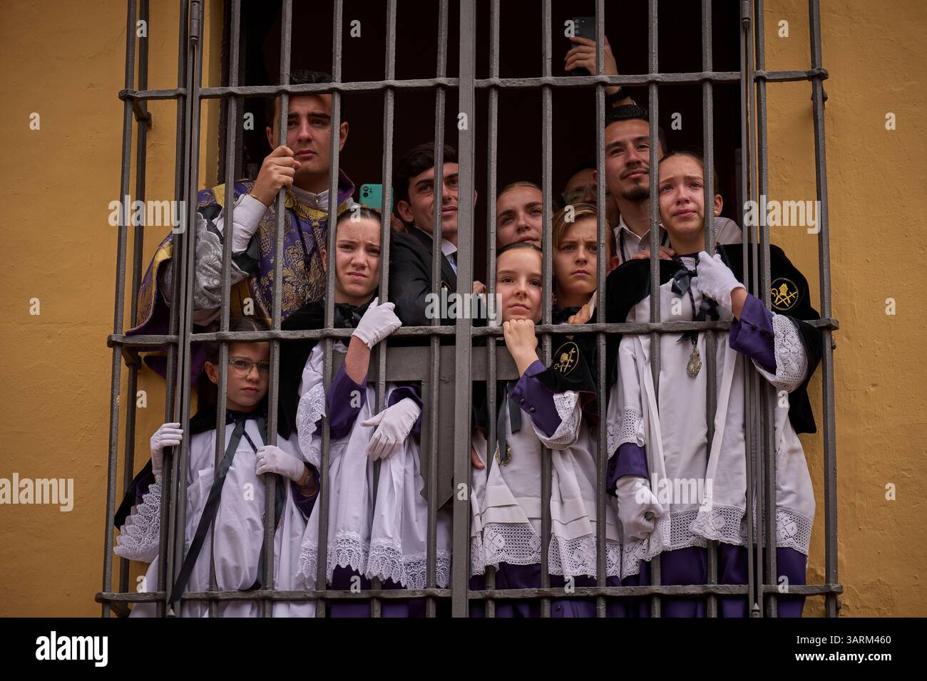 Altar servers crowd a window to watch a Christ of the San Bernardo ...
