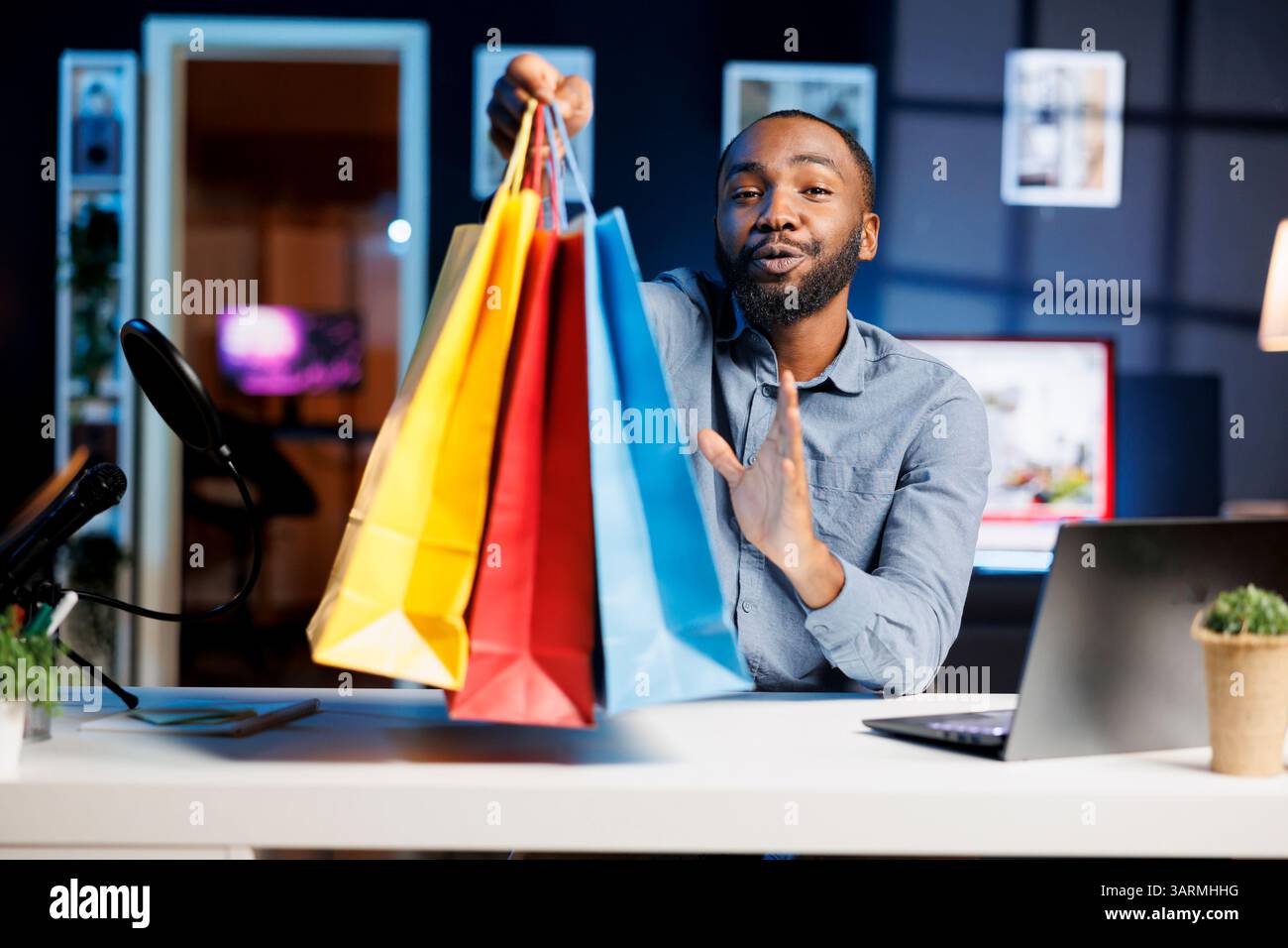 African american man holding shopping bags in hand, doing try-on haul ...