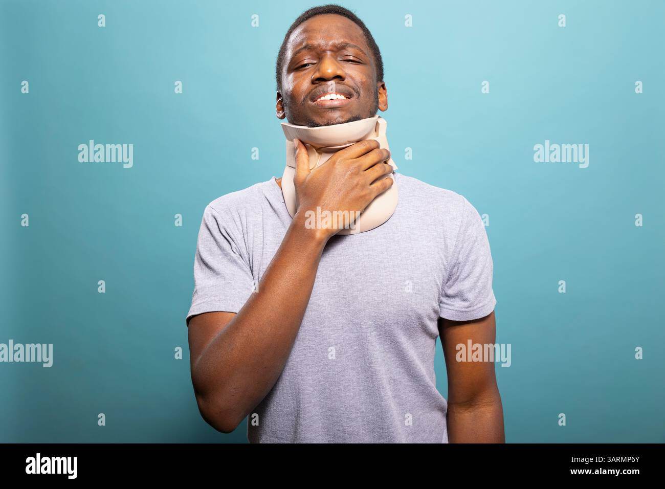 Portrait of injured black man touching his neck brace, looking at ...
