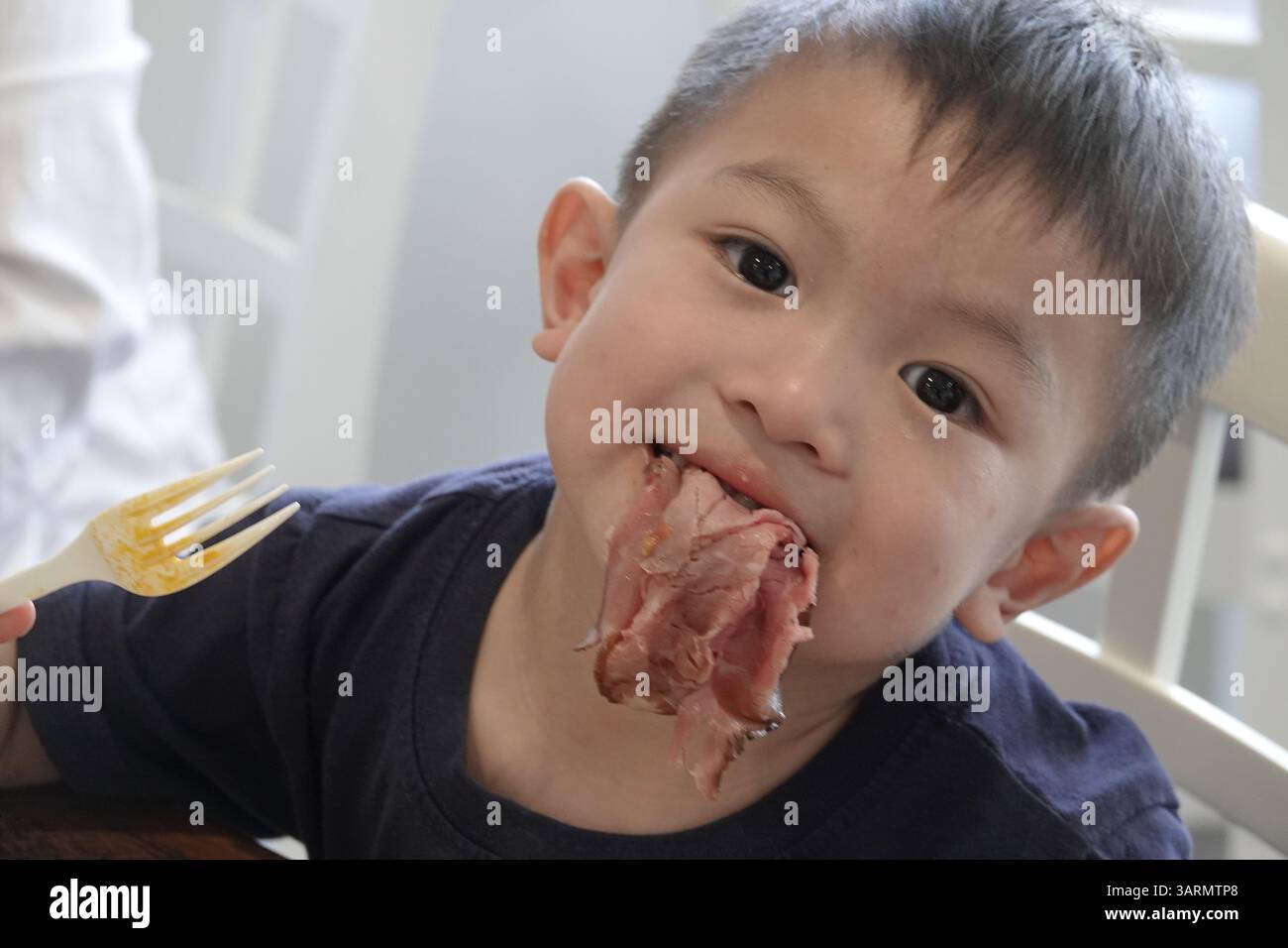 Monterey, CA., USA -6th April, 2025 Youngster enjoys his slice of ham ...