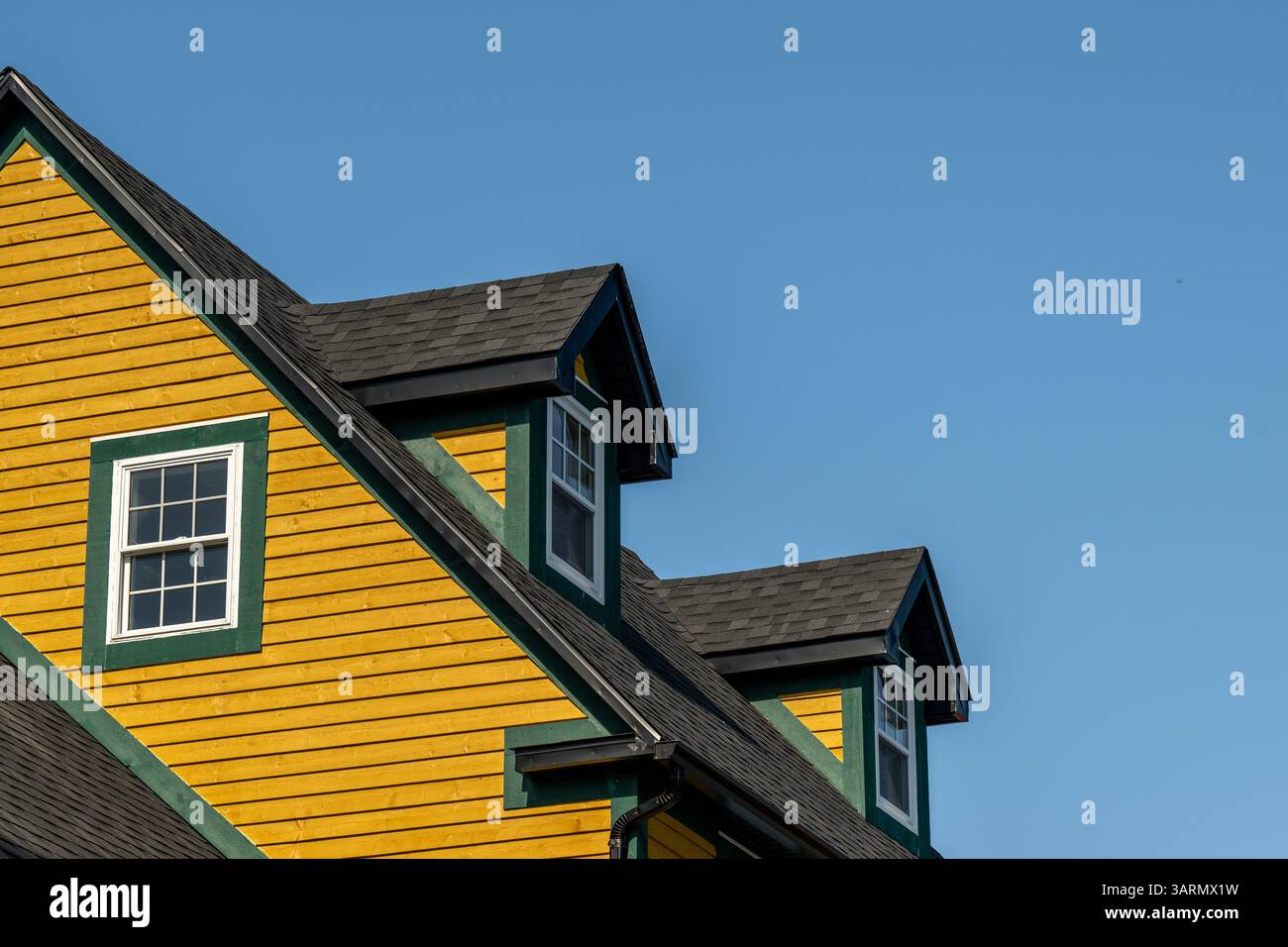 The top exterior floor of a yellow colored Cape Cod house with green ...