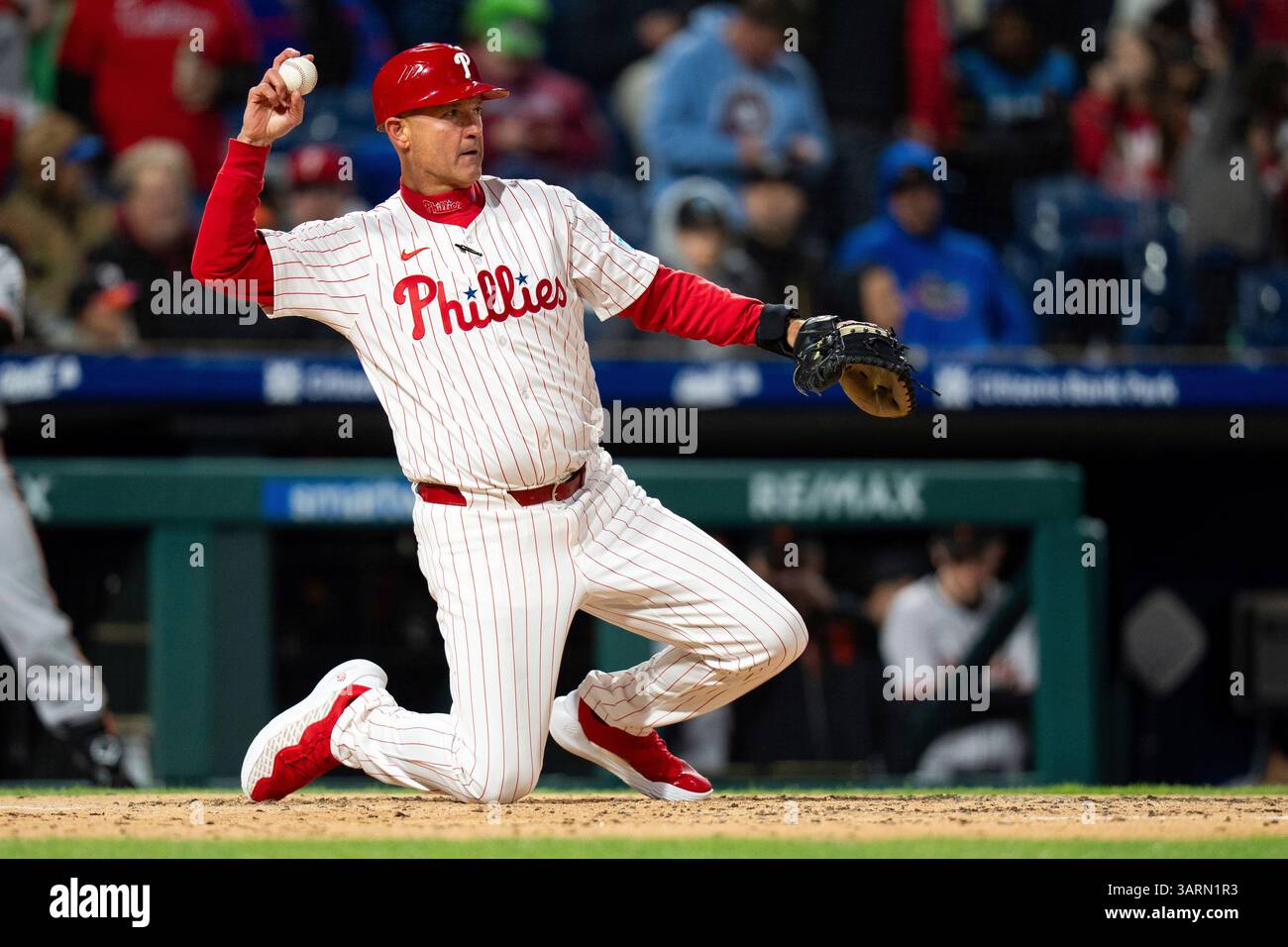 Philadelphia Phillies third base coach Dusty Wathan helps warm up the ...