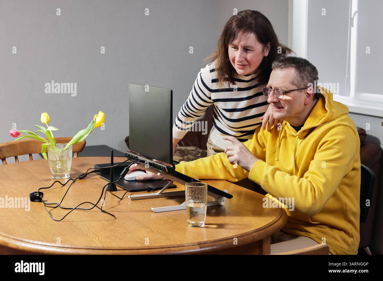 Woman watches man with glasses point at computer monitor placed on ...