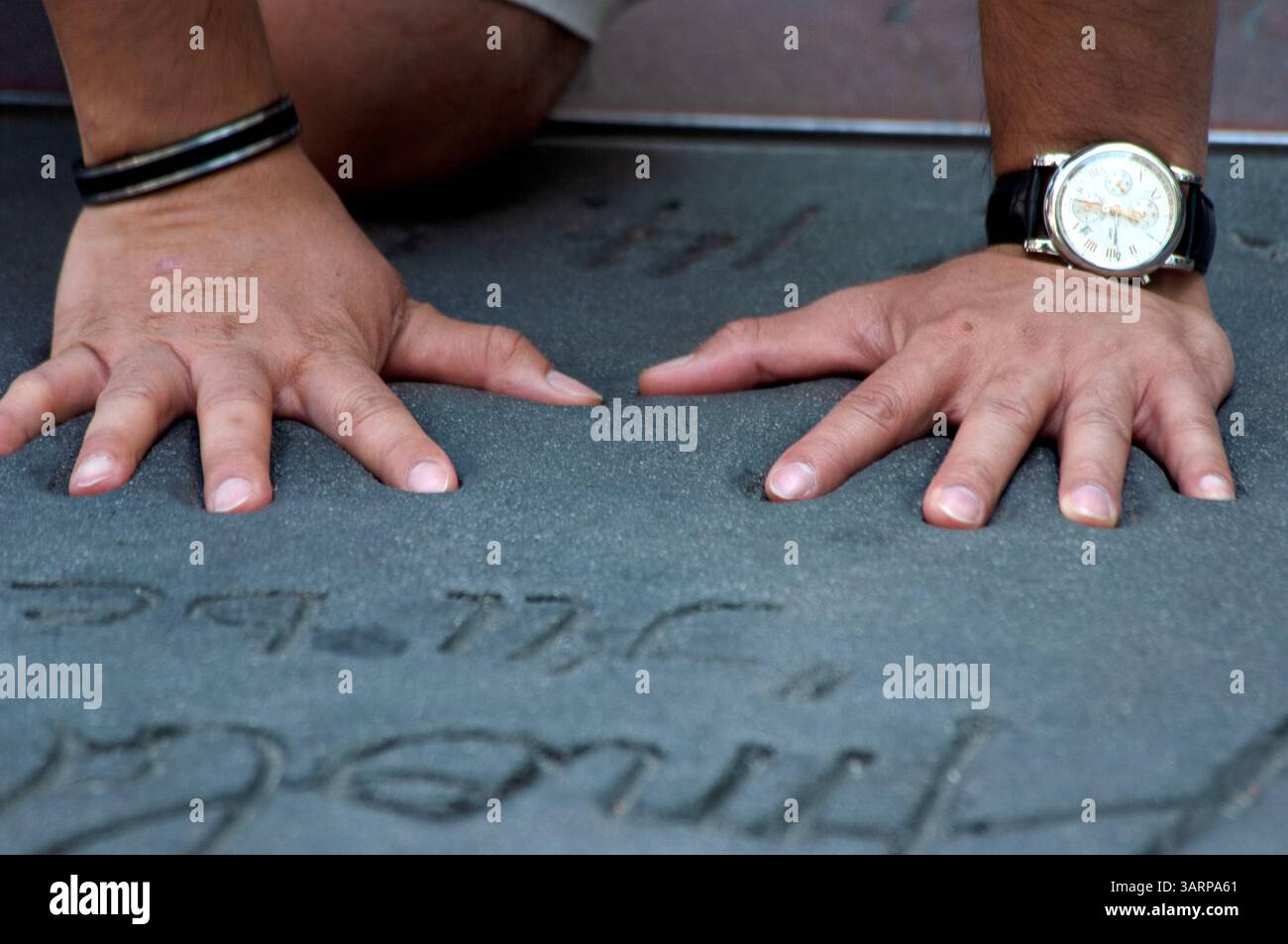 HOLLYWOOD, CALIFORNIA, USA: A man places his hands in some of the ...