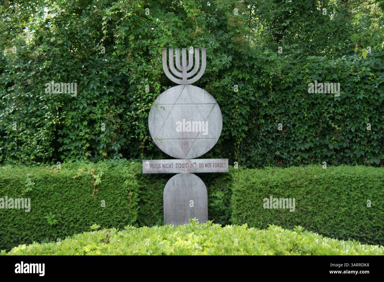 Stone memorial in Dahau featuring a menorah symbol and Hebrew ...