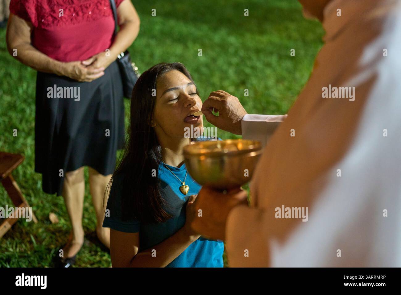A parishioner receives a host from a priest during a Holy Week Mass in Luque, Paraguay, Thursday ...