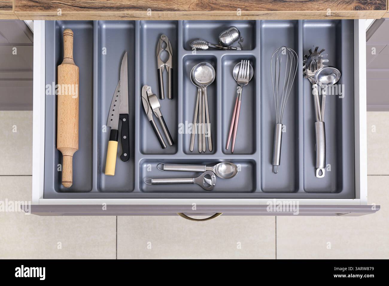 Open kitchen drawer with different silver cutlery Stock Photo - Alamy