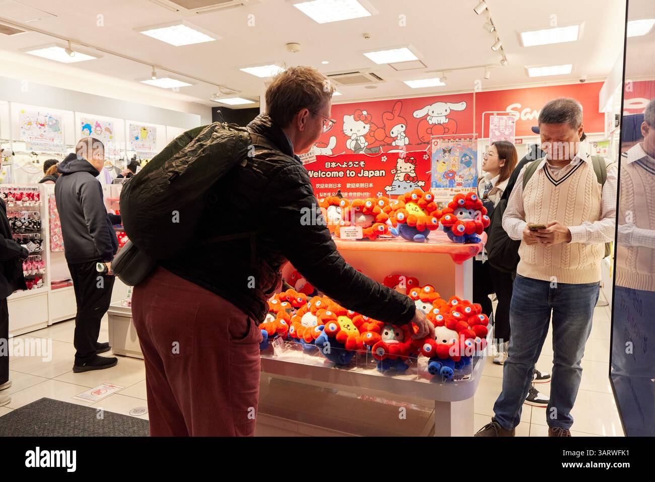 Foreign tourists pick up and look Myakumyaku souvenirs at a shop in ...