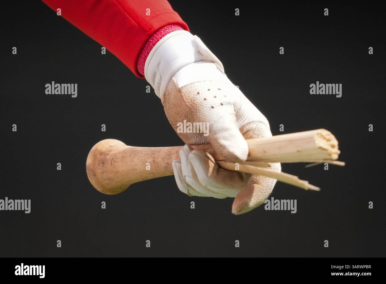 A Cincinnati Reds player holds a broken bat during a baseball game ...