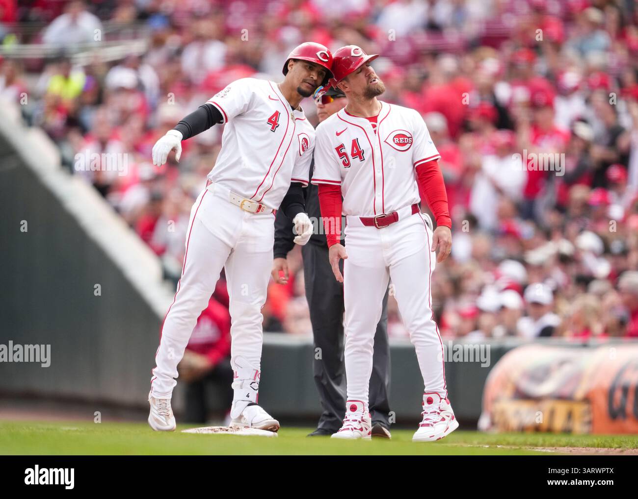 Cincinnati Reds' Santiago Espinal (4) celebrates with first base coach ...