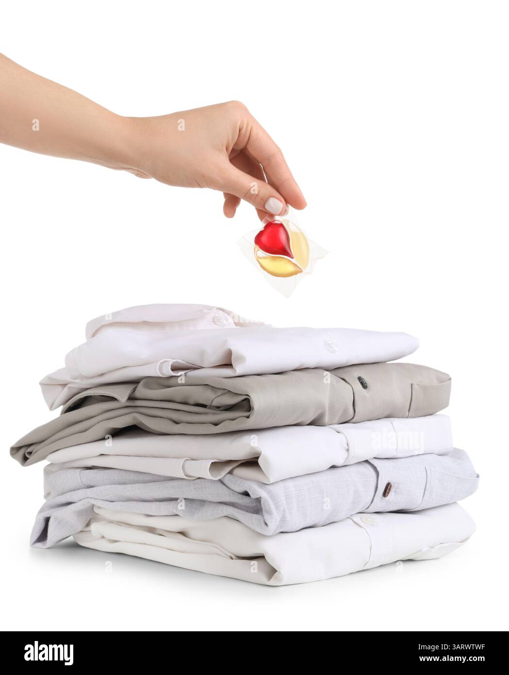 Female hand holding gel capsule with laundry detergent near stack of ...