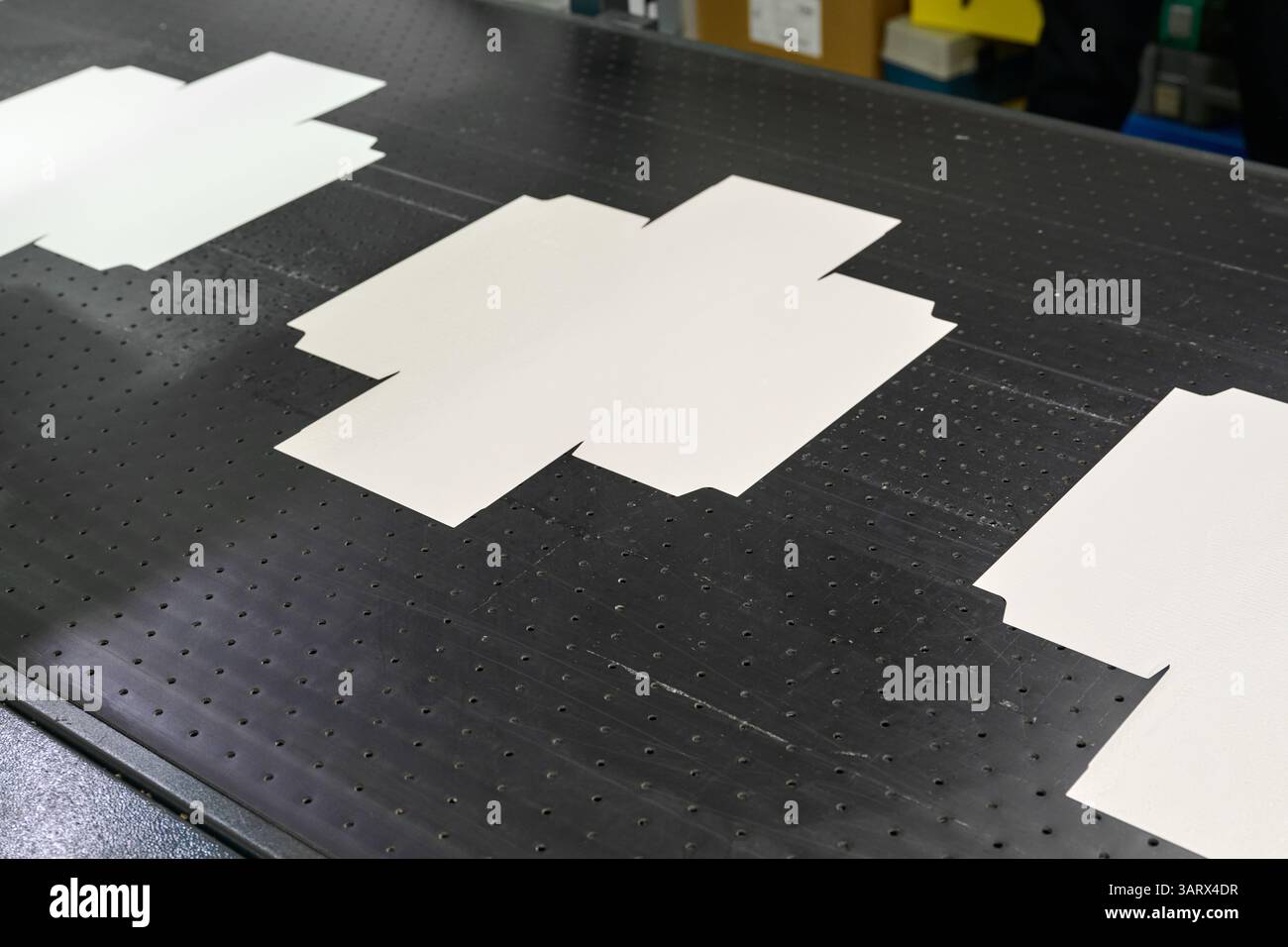 Cardboard packaging factory processes paper cutouts on conveyor belt after glue application in ...