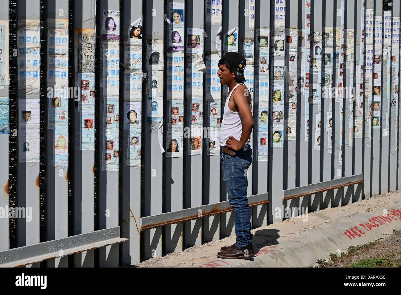 A man looks at photographs of missing persons attached to the Mexico-US ...