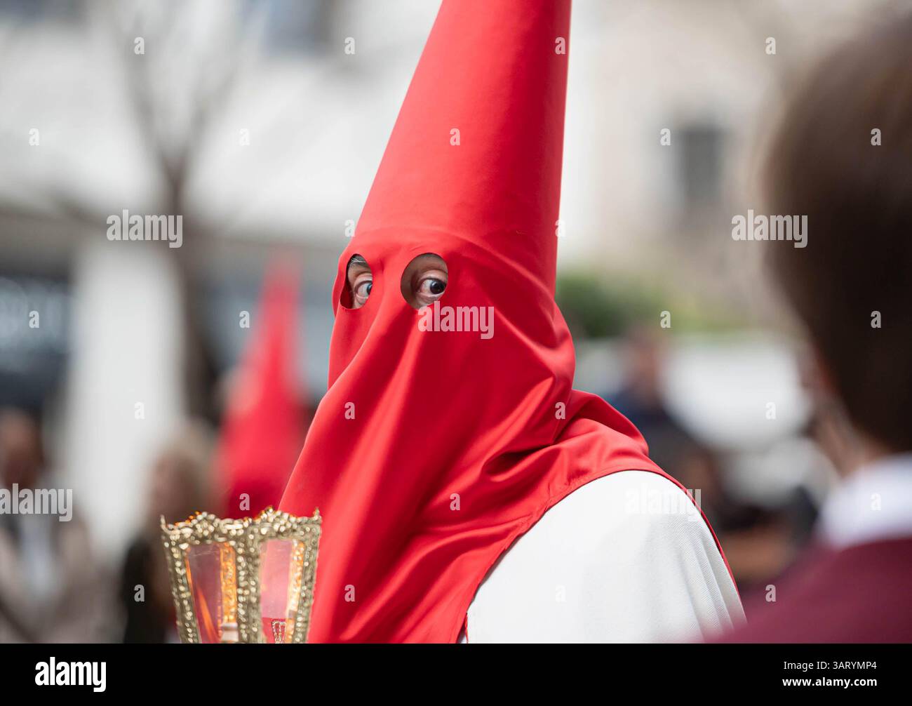 Madrid, Spain. 17th Apr, 2025. Portrait of a Nazarene in a red hood and ...