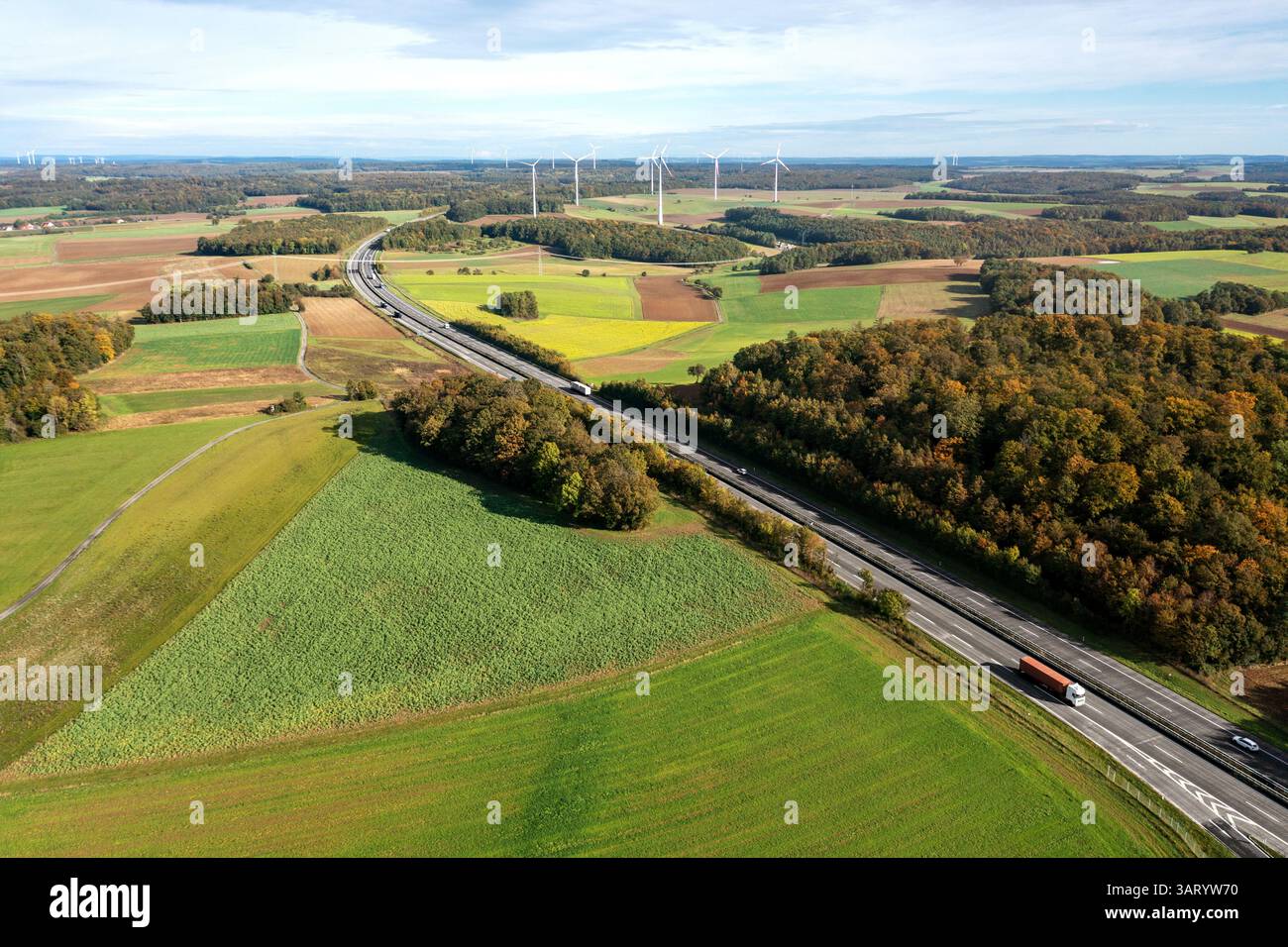 Drone aerial view in autumn with a two-lane highway and wind turbines ...